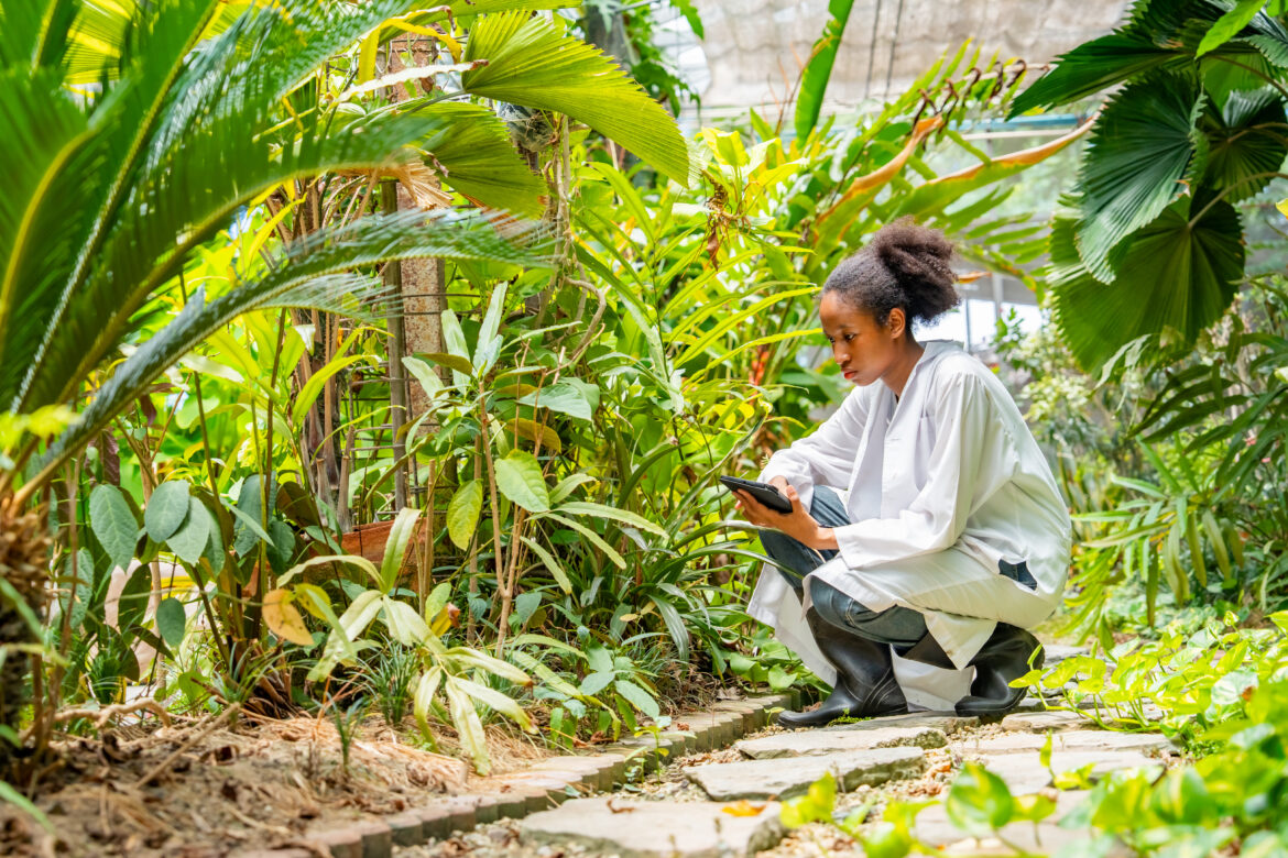 Happy teenage girl learning plant cultivation in botanical greenhouse ...